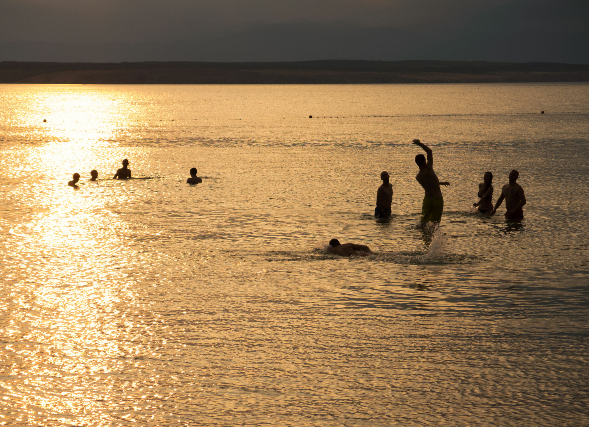 Silhouette Of Young People Playing In The Sea In Sunset | Copyright ...